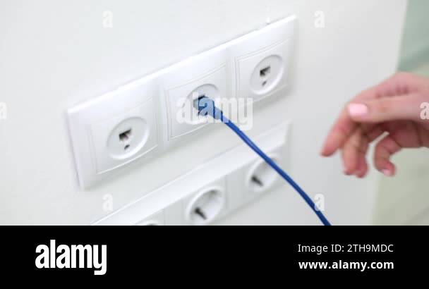 Person get Wi-Fi cable from wall outlet. Blocking and turning off ...