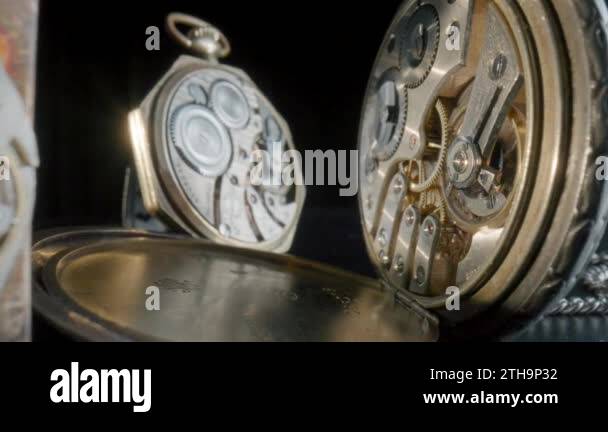 Three antique pocket watches with a working clockwork on isolated black ...