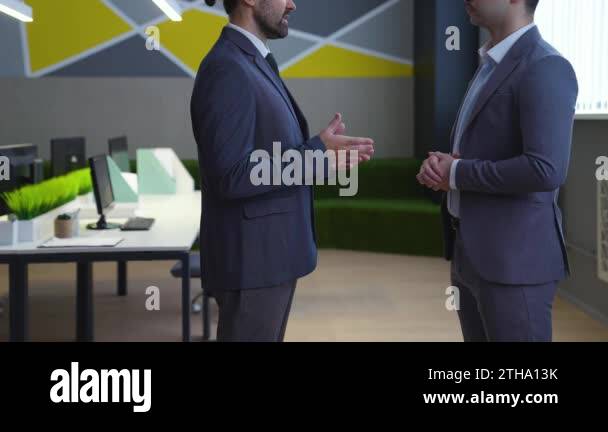 Two men in suits in the office are talking, negotiating, talking about ...