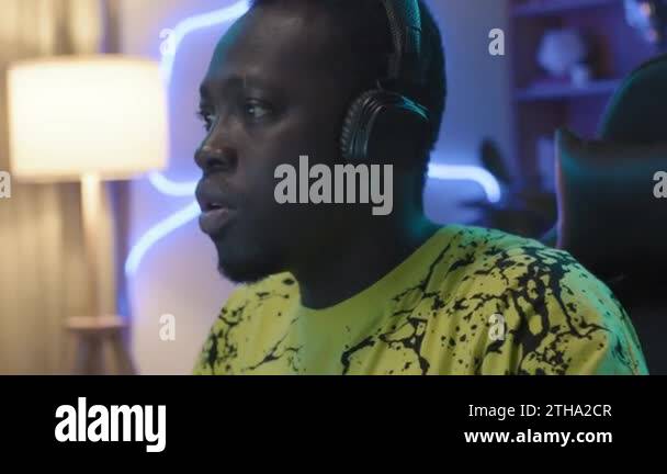 Medium close-up shot of teenage black male gamer with headphones ...
