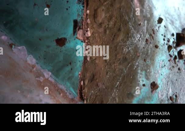 Turquoise pure color of ice inside the ice cave. Stones and icicles are ...