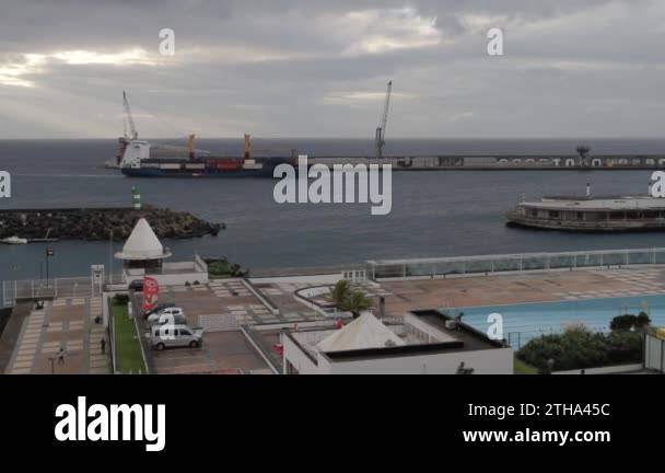 A large cargo ship is entering the Ponta Delgada port, at the island of ...