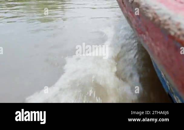 Water splashed from front side view of the wooden boat it was driving ...
