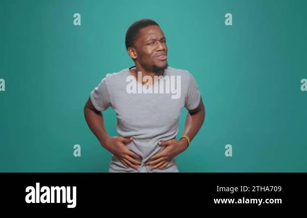 Portrait of male model having stomach ache and abdominal cramp, dealing ...