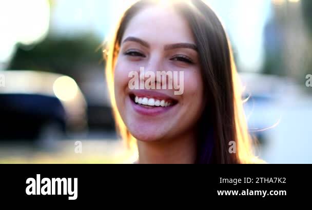 Young woman portrait smiling with lens-flare outside. Millennial girl ...