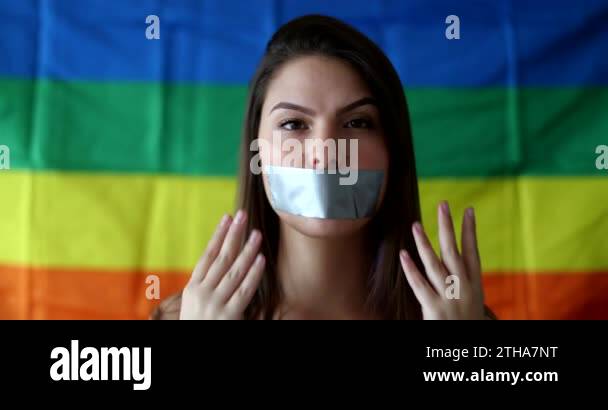Young woman covering mouth with duct tape. LGBT censorship concept ...