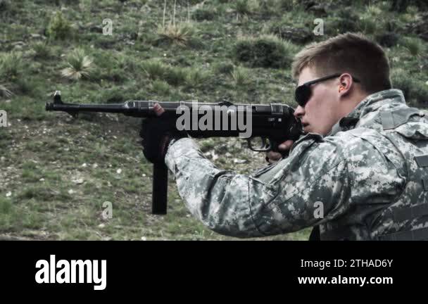 Soldier shooting a sub machine gun in slightly slow motion. Looks like ...