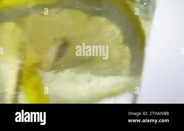 Macro refreshing soda tonic fizzy sparkling water, lime in glass, ice cubes. Slice of lemon ...