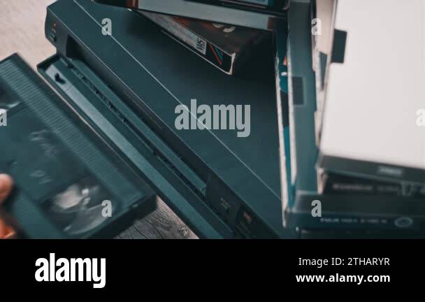 Insert VHS cassette into VCR player. Black vintage videotape cassette ...
