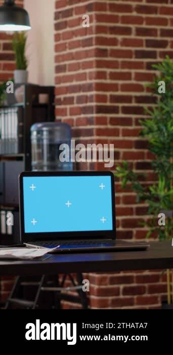Vertical video: Empty business office with greenscreen on laptop ...