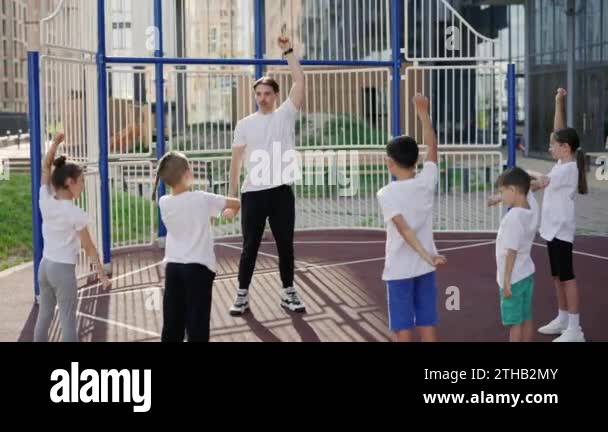 School teacher shows how to get exercises to little children from ...