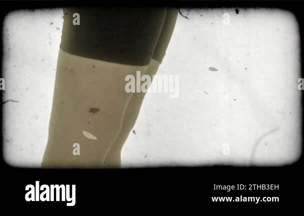 Pan upward of profile of woman's body, dressed in black latex exercise ...