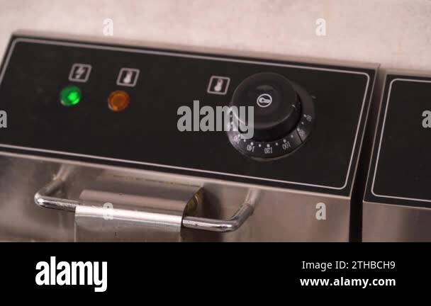 Working deep fryer. Chef is controlling the frying process by ...