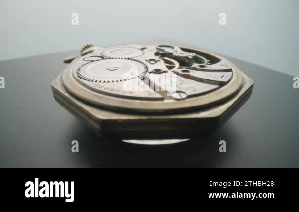 An antique pocket watch with an open working clock mechanism rotates on ...