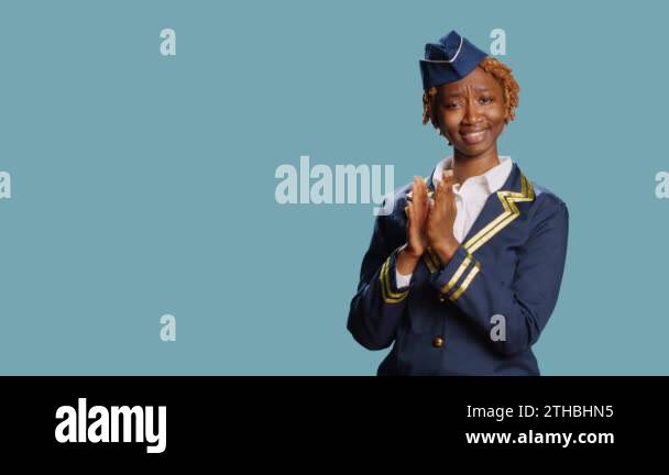 Young stewardess applauding in studio, cheering for something doing ...