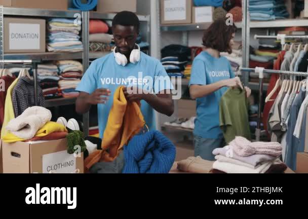 Volunteers sorting out donated clothes in community charity donation ...