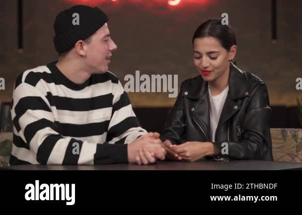 Love couple sitting at restaurant table. Man touching woman's hands ...