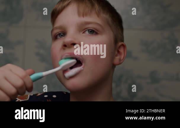 Boy Brushes Teeth Close Up. Portrait of kid brushing teeth looking at ...