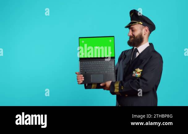Happy young pilot holding laptop with greenscreen, using chroma key ...