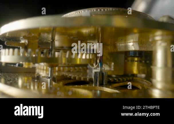 Inside view of a moving clockwork of golden mechanical clock on black ...
