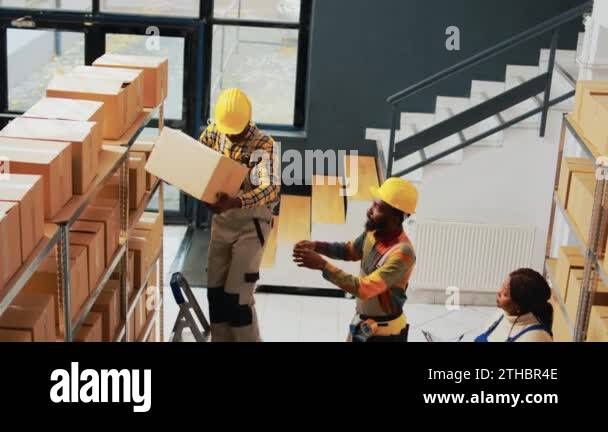 Group of people working on stock logistics in depot, organizing pallets ...
