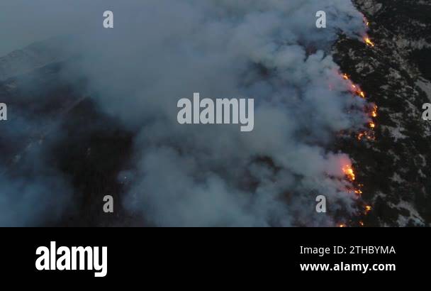 Aerial panoramic view of a forest fire at night, heavy smoke causes air ...