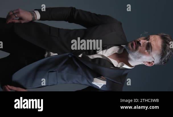 elegant businessman rubbing his palms, putting hands in pockets ...