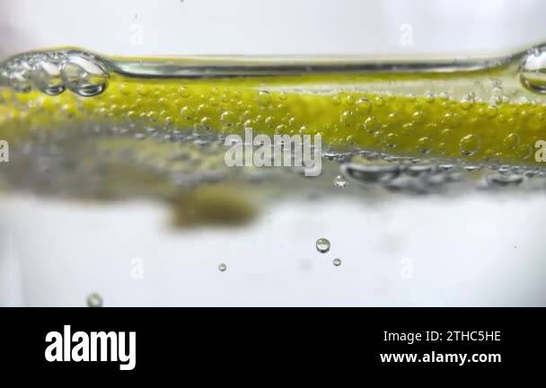 Macro refreshing soda tonic fizzy sparkling water, lime in glass, ice cubes. Slice of lemon ...