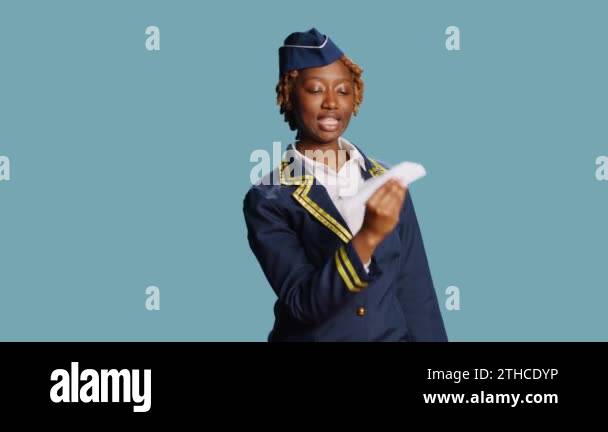 Cheerful silly stewardess playing with paper plane, having fun with ...