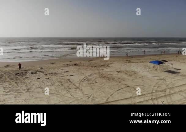 Low altitude flying over the beach diagonally towards the ocean with ...