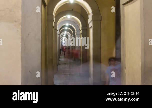 People walking inside arches of the Vasari Corridor night timelapse in ...