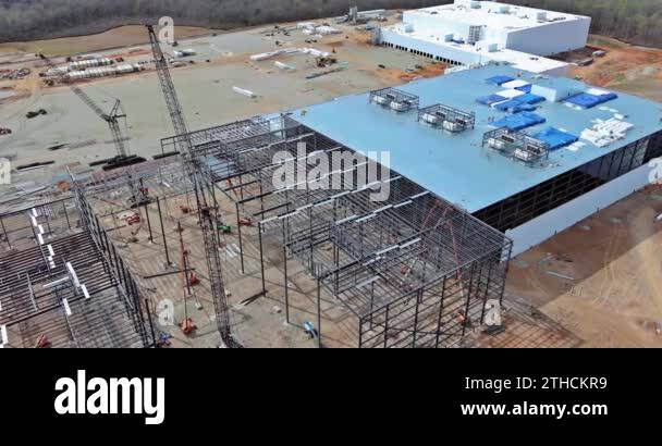 An industrial building is constructed use crawler cranes metal steel ...