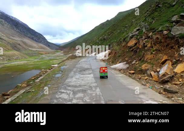 Drone shot following a tuk tuk on the Babusar Pass mountain pass in ...
