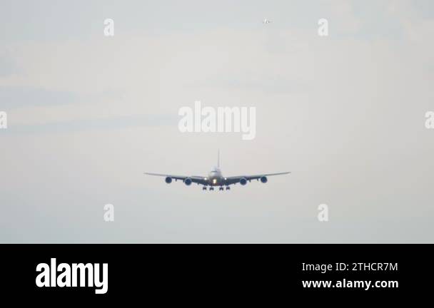 Long shot of a four-engine double-deck wide-body aircraft approaching ...