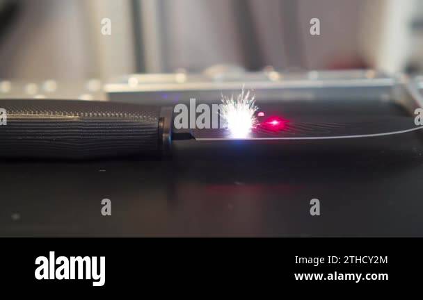 Camera horizontally passing by hunting knife in laser engraving process ...