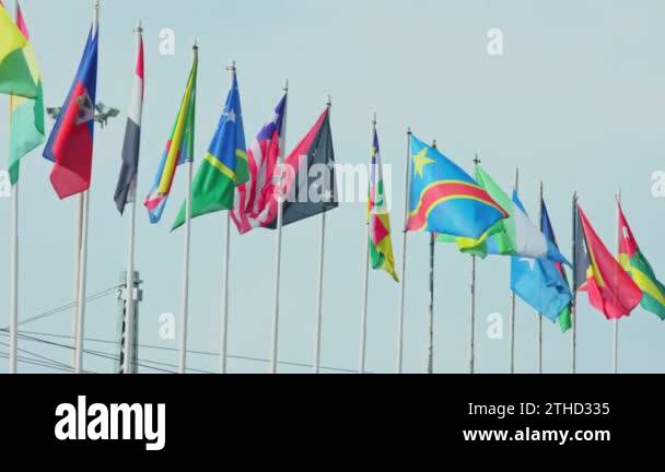 Flags of different countries flutter in the wind on the sky background ...