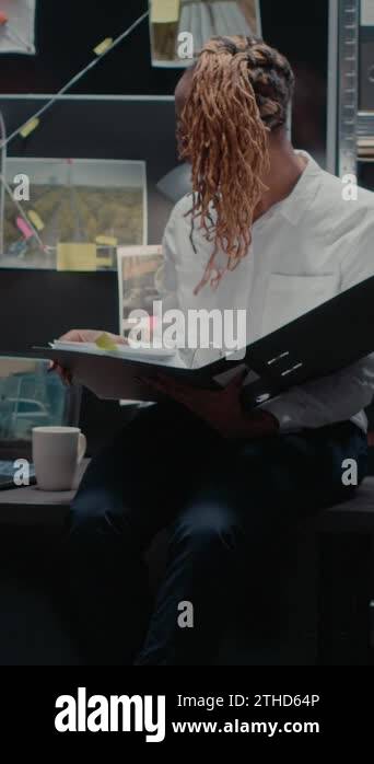 Vertical video: Two police officers looking at detective evidence map ...