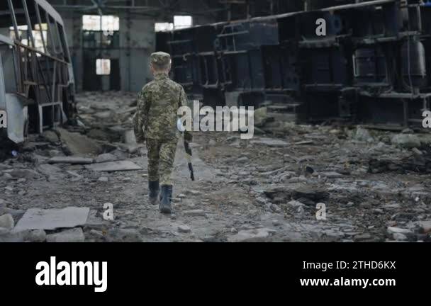 Back View of the Little Soldier Going Through the Ruins Holding the Toy ...