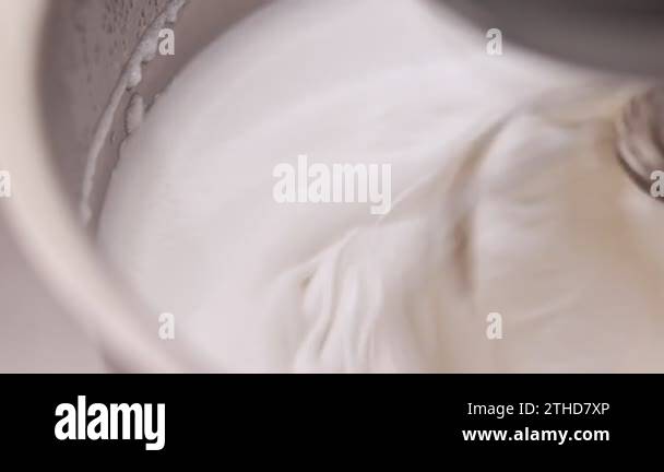 Kitchen mixer is beating the eggs white egg whites into a thick white ...