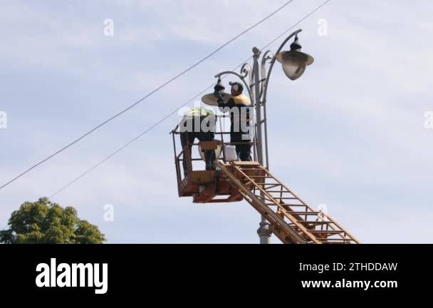 Technician on aerial, worker repair, street lamp. Worker repairing ...