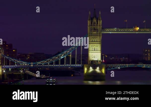 A panning shot - from left to right - of lit Tower Bridge (in London ...