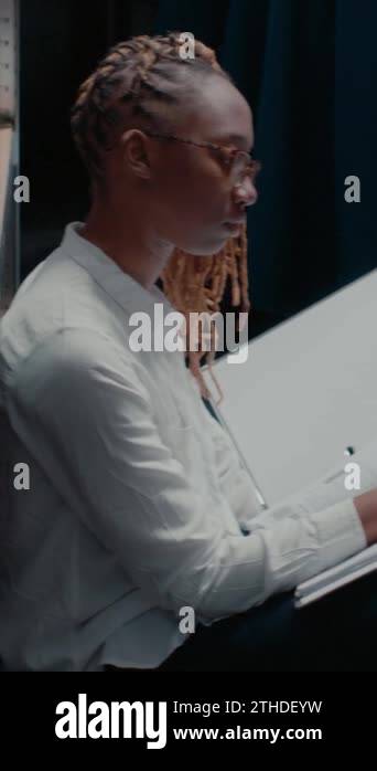 Vertical video: Police inspector taking notes on research case files ...