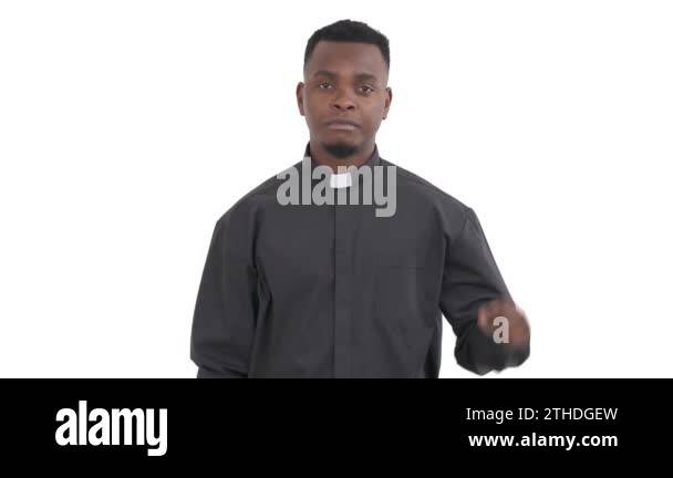 Portrait of black sad priest pointing finger down and shaking his head ...