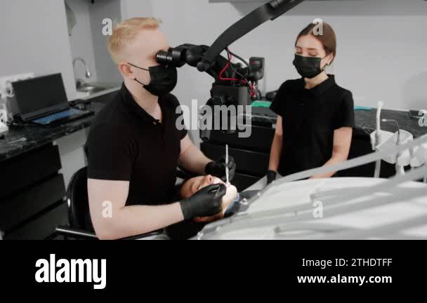 At the dental clinic a dentist examines a patient with toothache under ...