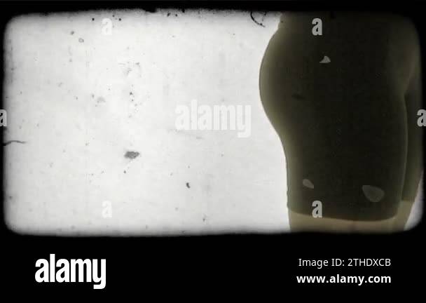 Pan upward of profile of woman's body, dressed in black latex exercise ...