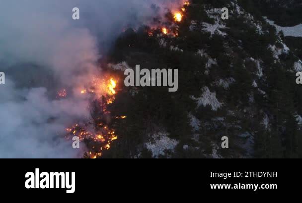 Aerial panoramic view of a forest fire at night, heavy smoke causes air ...