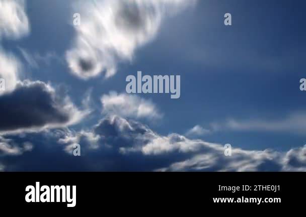 Time lapse, lens flare of dark rolling clouds in the sky lit from ...