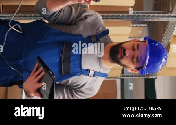 Vertical video: Young adult scanning barcodes on boxes in warehouse ...