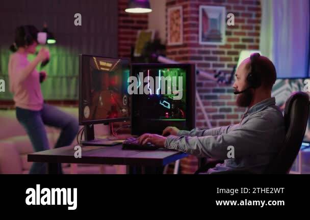 Static tripod shot of gamer playing multiplayer first person shooter on ...