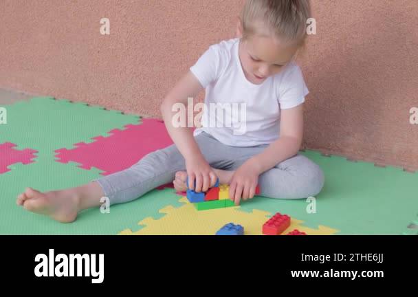 little girl taking apart his lego constructor bricks toys and placed in ...